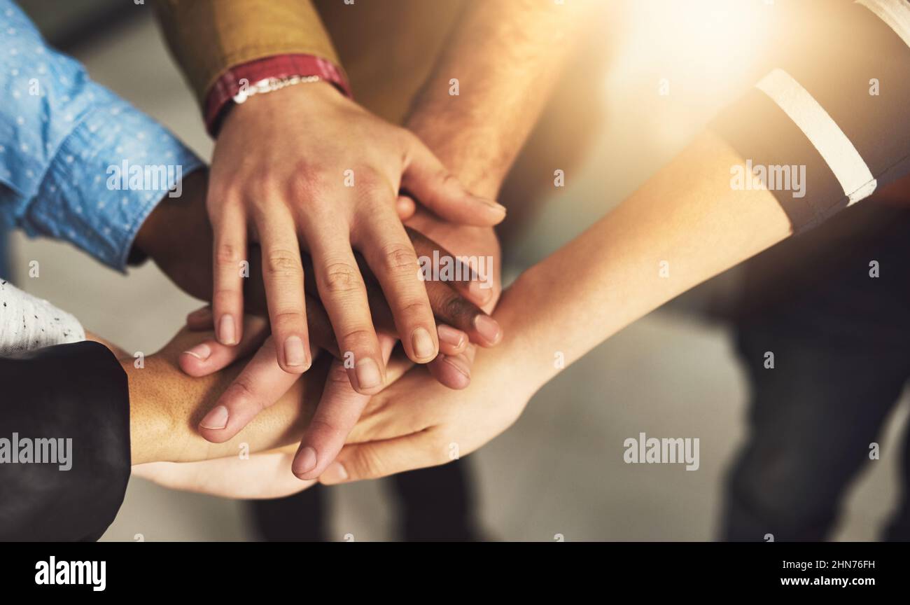 Were united as a team. Shot of a group of people putting their hands ...