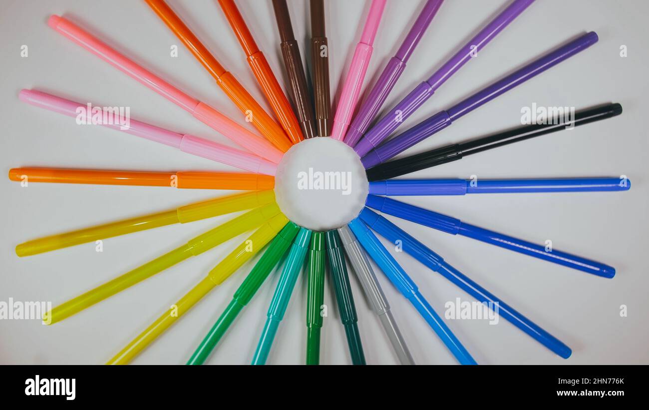 Many colored pencils are arranged around the edges of the image as a ...
