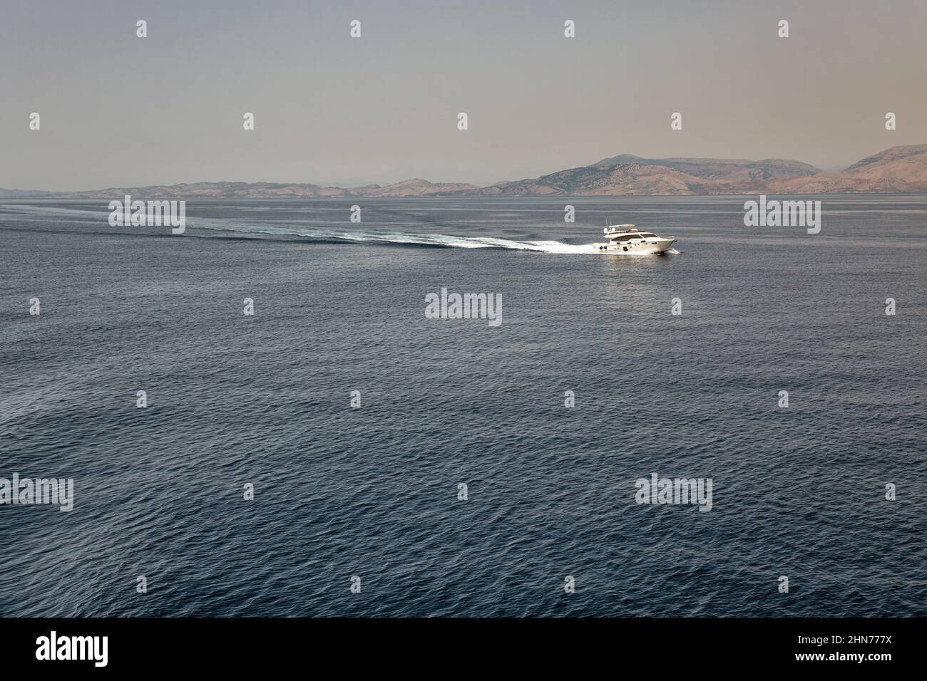 Seascape with speed motor boat sails in the distance off the coast of ...