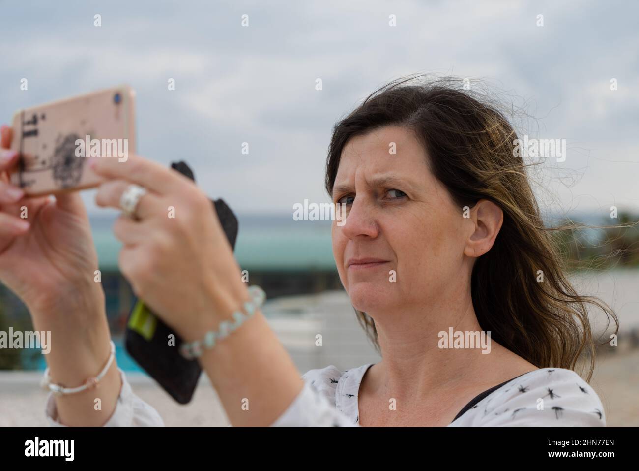 Caucasian woman with brown hair taking a photo and looking at the ...