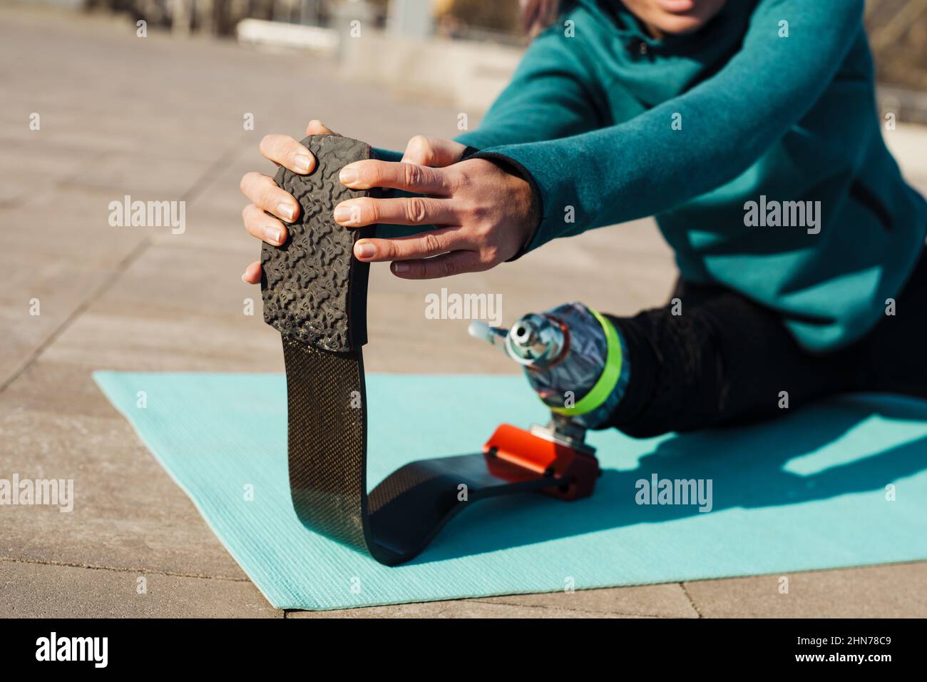 Young sportswoman with prosthesis doing exercise while working out on ...