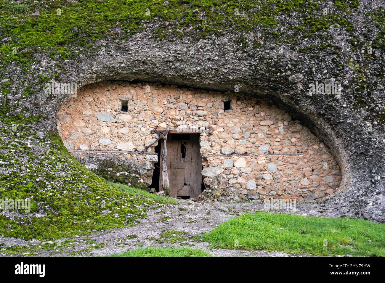 An old dwelling under a hill overgrown with grass and vegetation in the ...