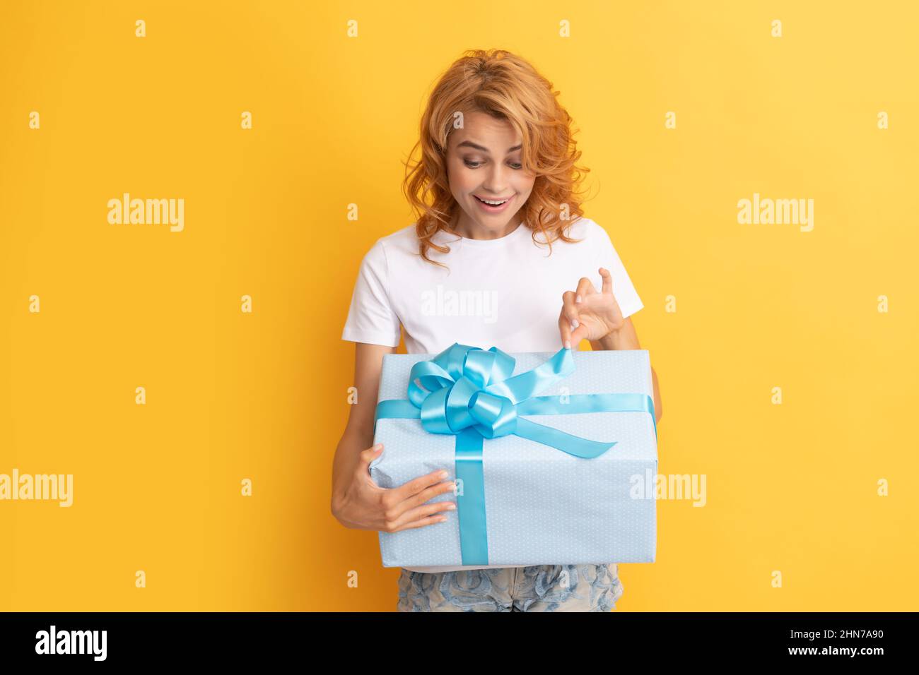curious happy redhead woman open gift box. anniversary Stock Photo - Alamy