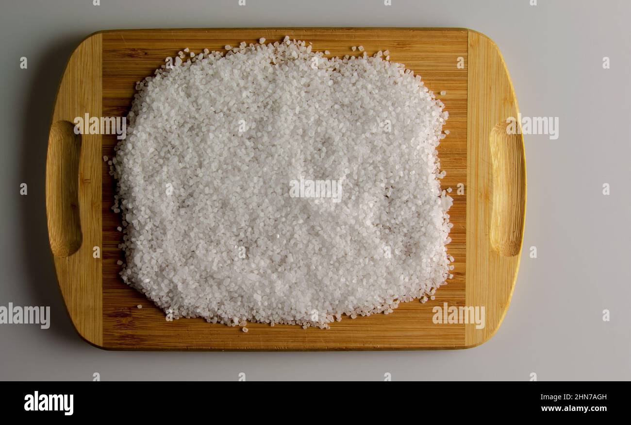 Background of coarsely ground salt on a wooden kitchen board. Texture ...