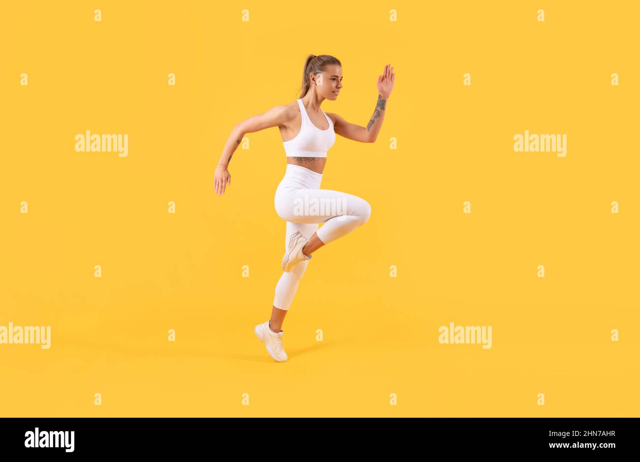 active fitness girl runner running on yellow background Stock Photo - Alamy