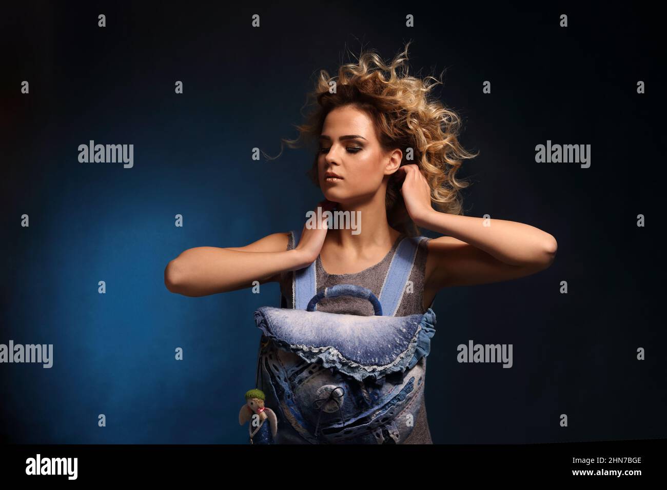 girl with a backpack poses on a blue background Stock Photo - Alamy