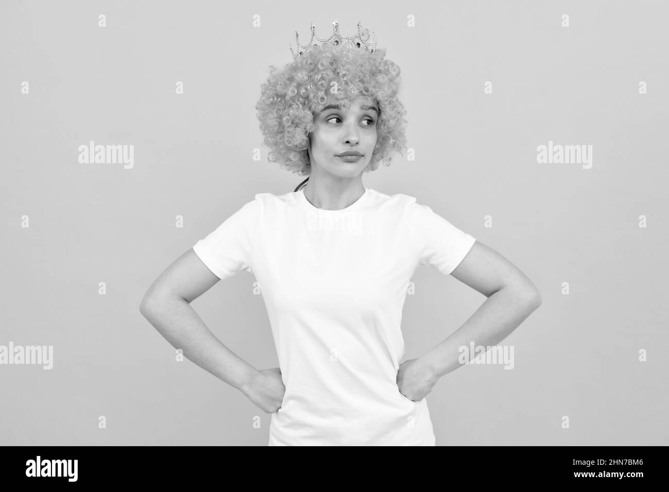 happy freaky selfish woman in curly clown wig and queen crown for party ...