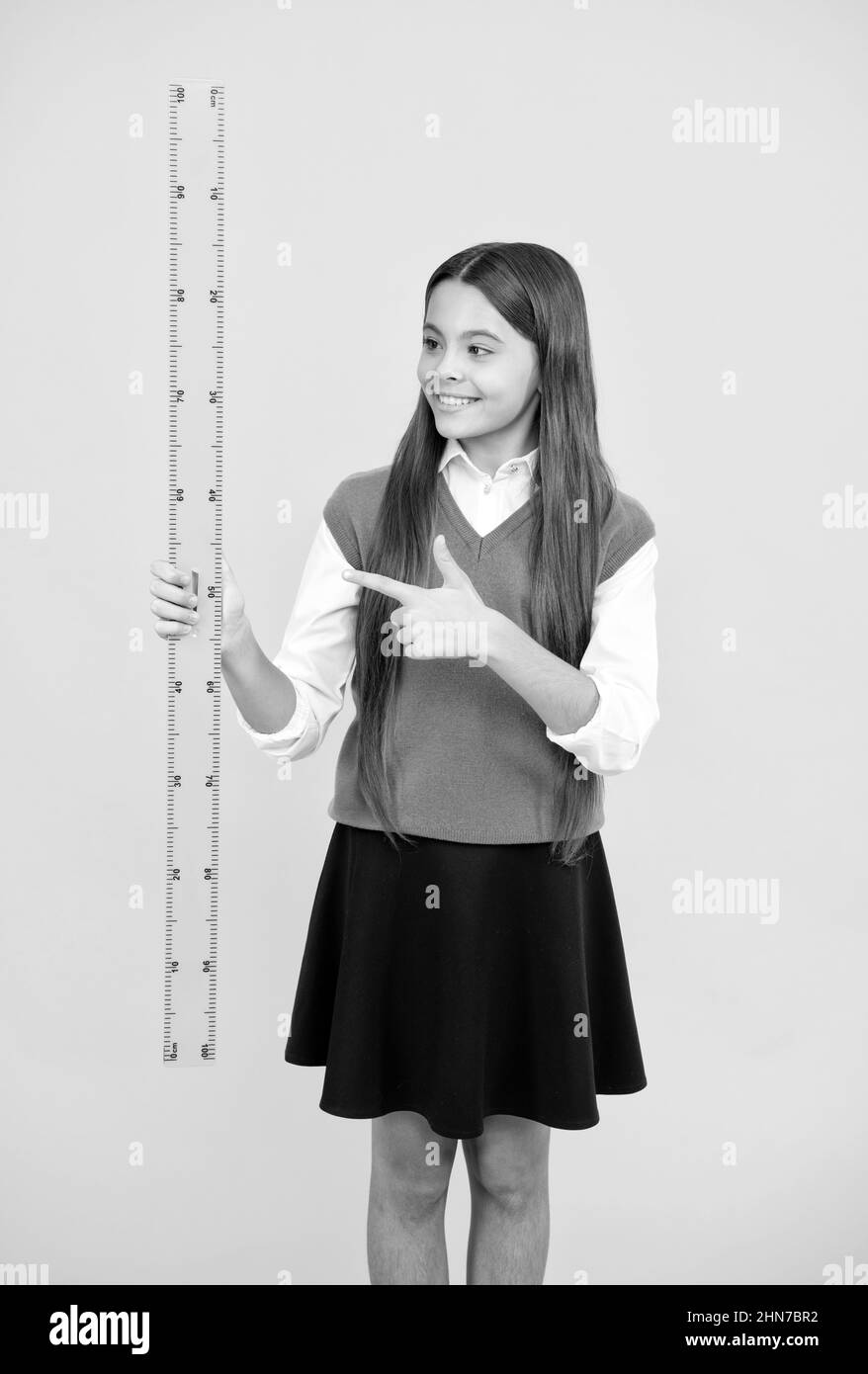 cheerful teen girl study math pointing finger on ruler measuring size ...