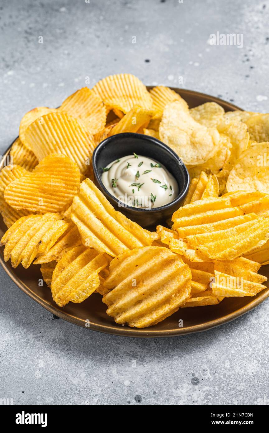 Variety of Potato chips in a plate served with dip sauce. Gray ...