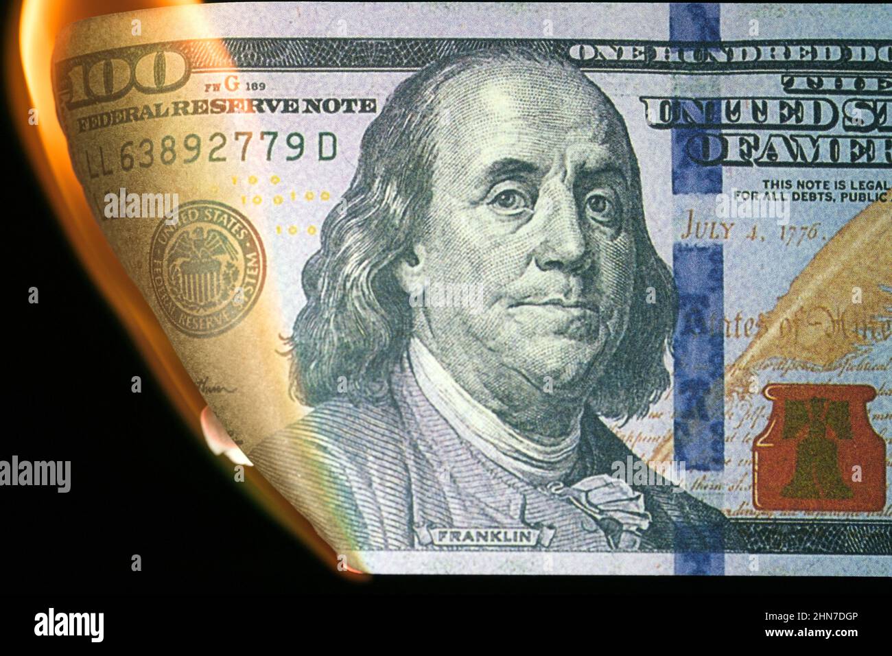 Close up shot of a 100 dollar banknote burning on a black background ...