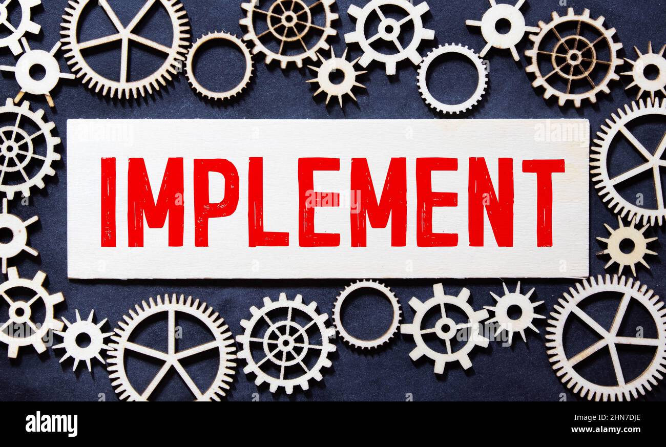word Implement on black torn paper Stock Photo - Alamy
