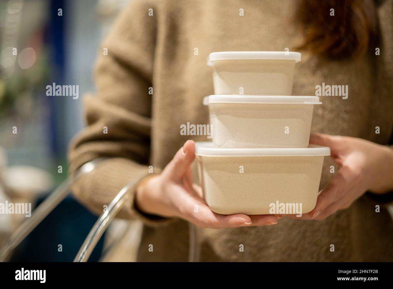 Closeup female hands holding stack of ceramic containers with plastic ...