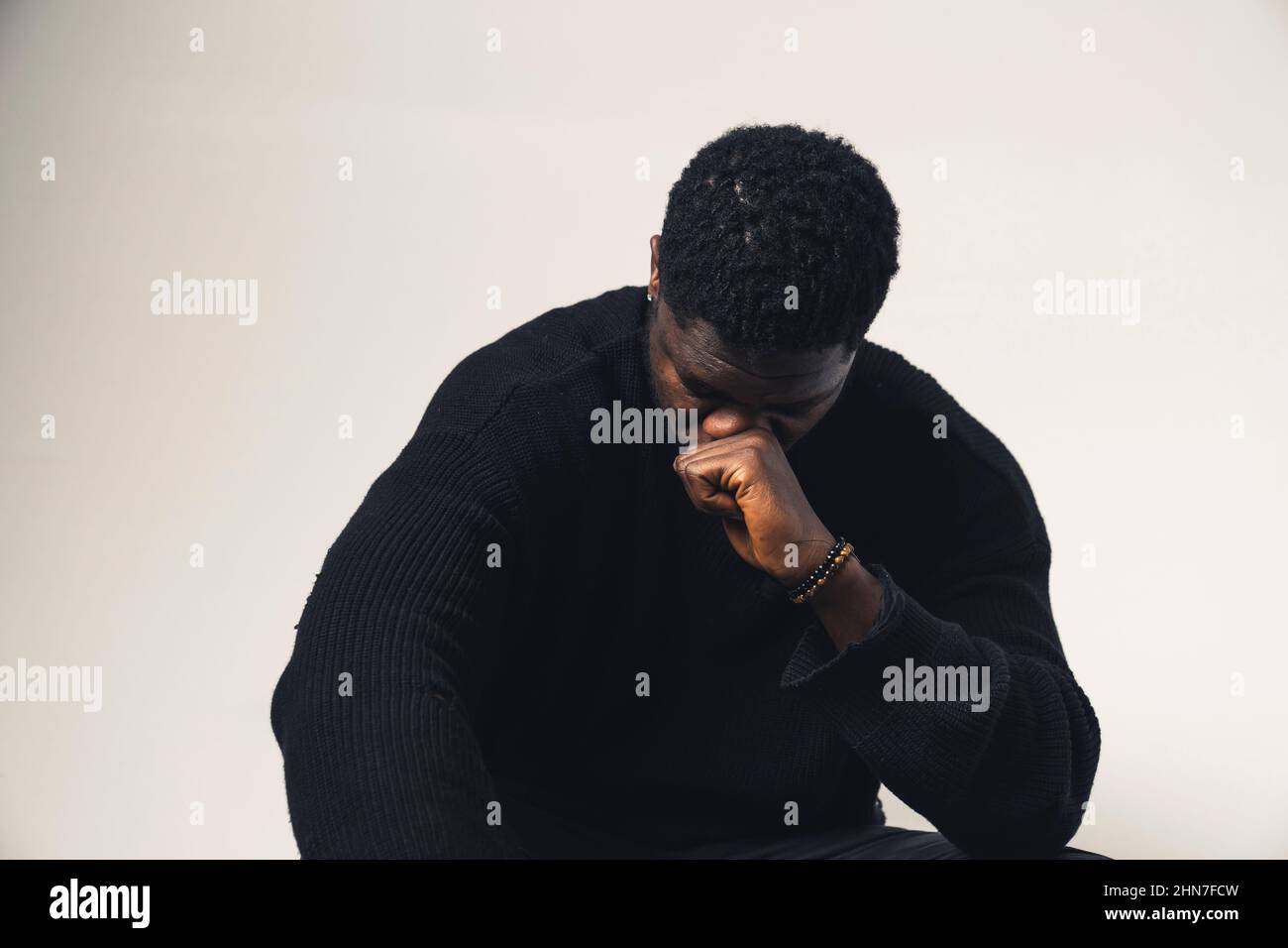 beaten man of color with fist in his face looking down white background ...