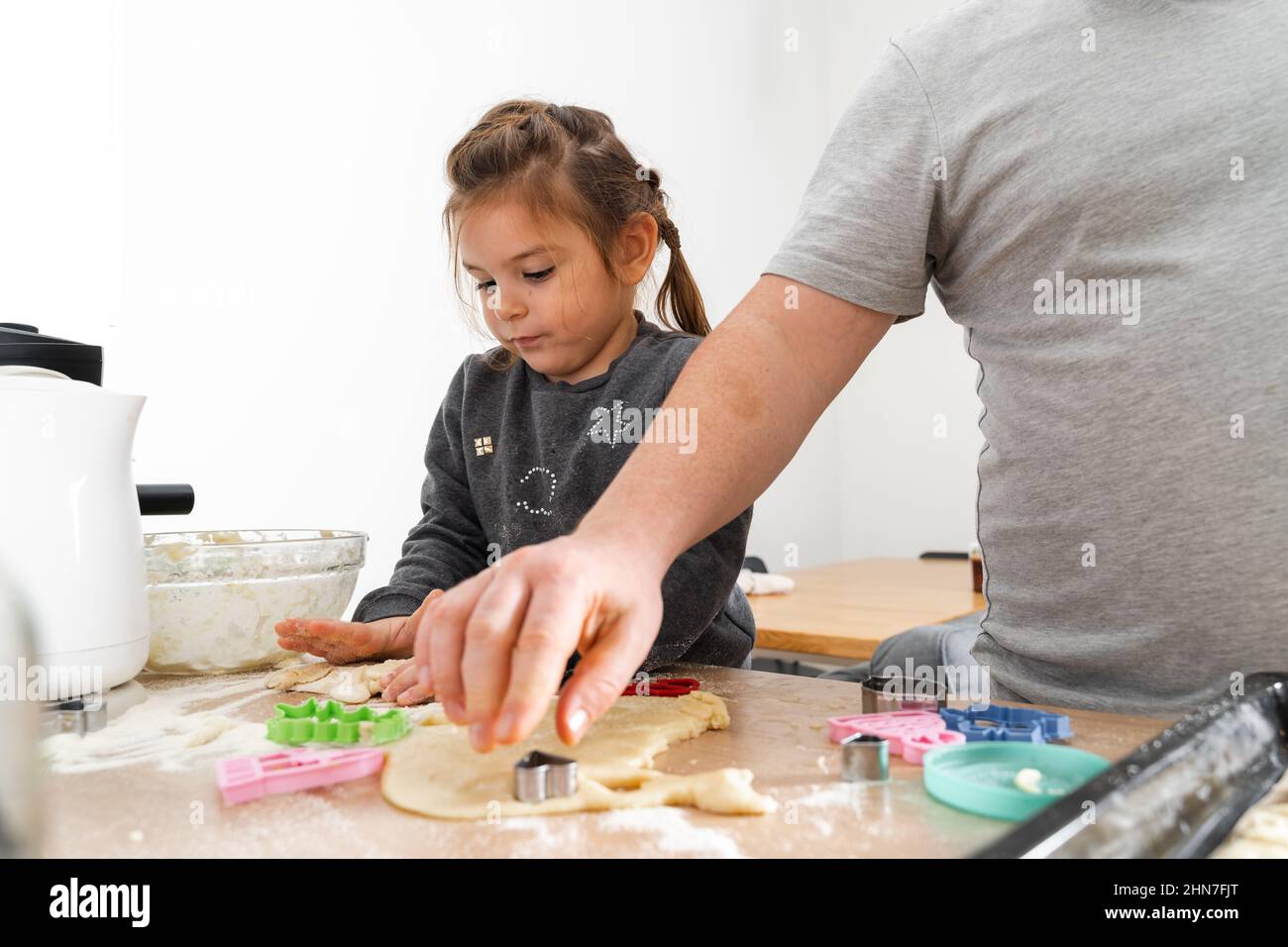 Cropped view of unrecognizable man and his daughter making sweets with ...