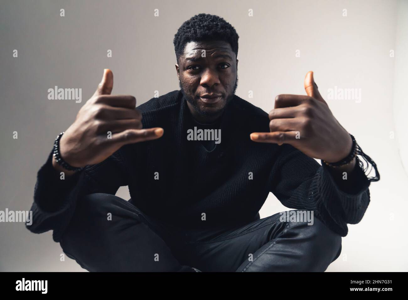Afroamerican men with shaka sign seated chill white background - mid ...