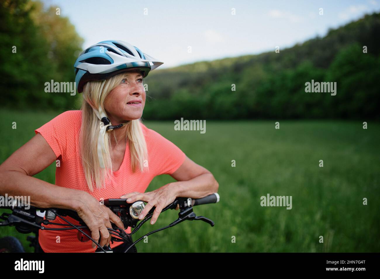 Cheerful active senior woman biker outdoors in nature Stock Photo - Alamy