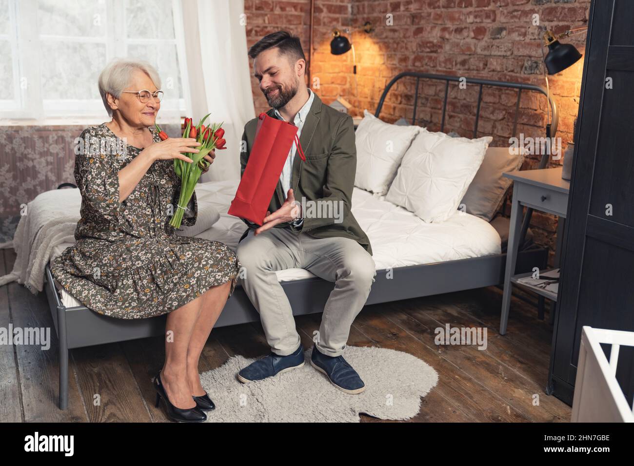 grey-haired caucasian grandma positively surprised with a bouquet of ...