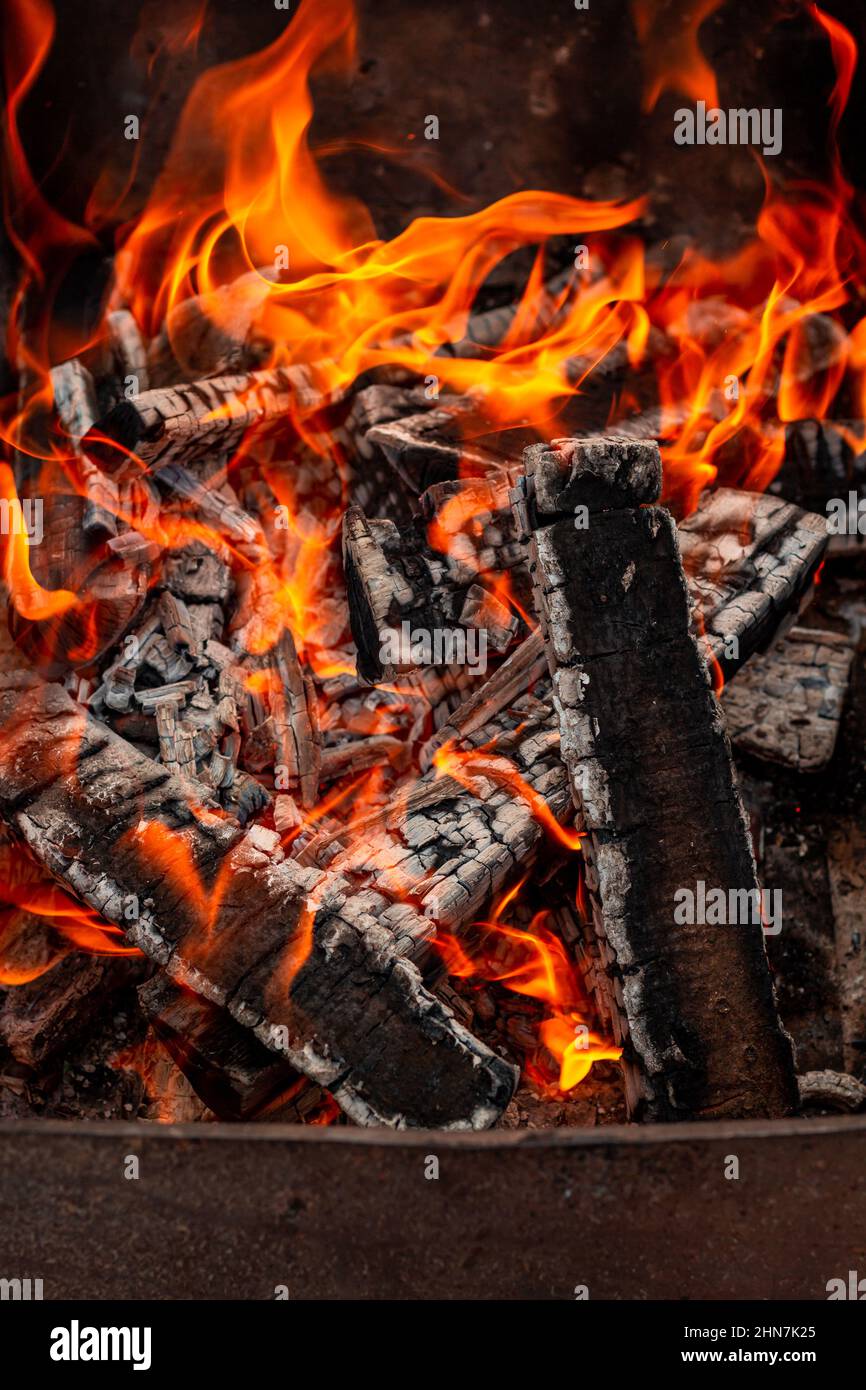 Closeup of a Charred wood burning in a orange yellow flames Stock Photo ...