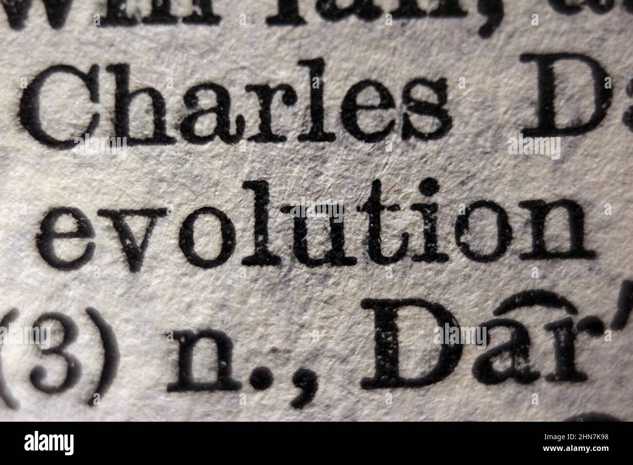 Word evolution printed on Charles Darwin dictionary page, macro close ...