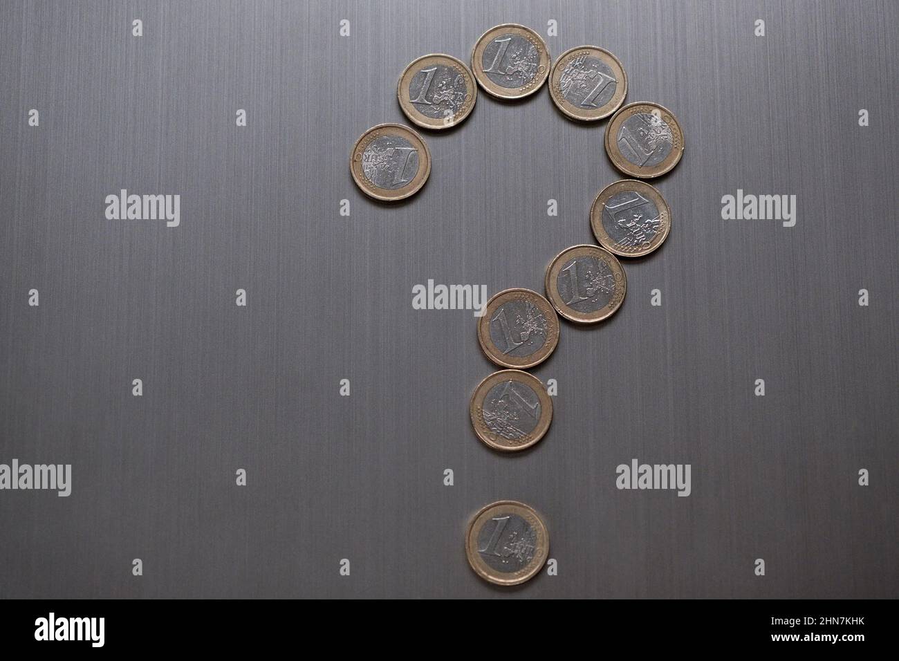 Question mark made of one euro coins on a metallic background. European ...