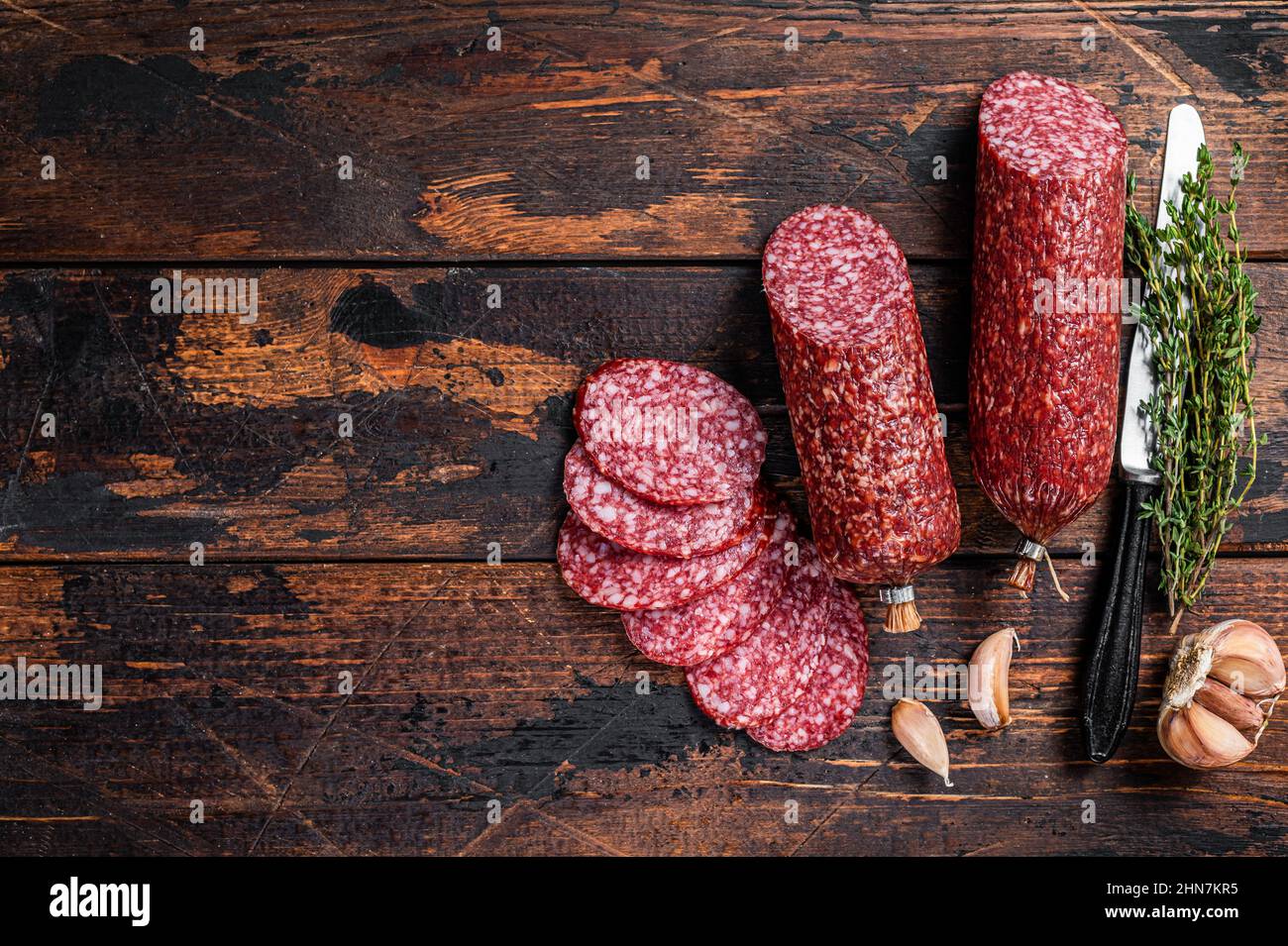Sliced salami cured sausage on kitchen table. Wooden background. Top ...
