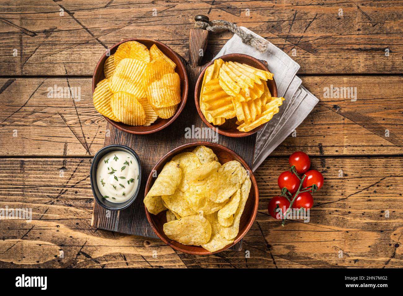 Variety of Potato chips - Crinkle, homemade, hot BBQ. Wooden background ...