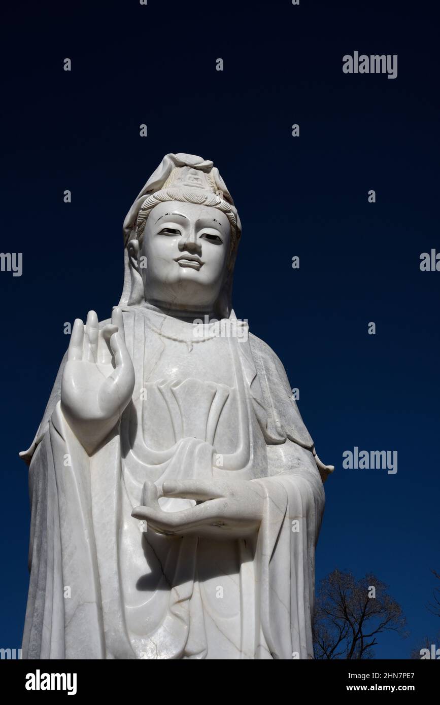 A statue of Quan Am, the bodhisattva of compassion, in front of a ...