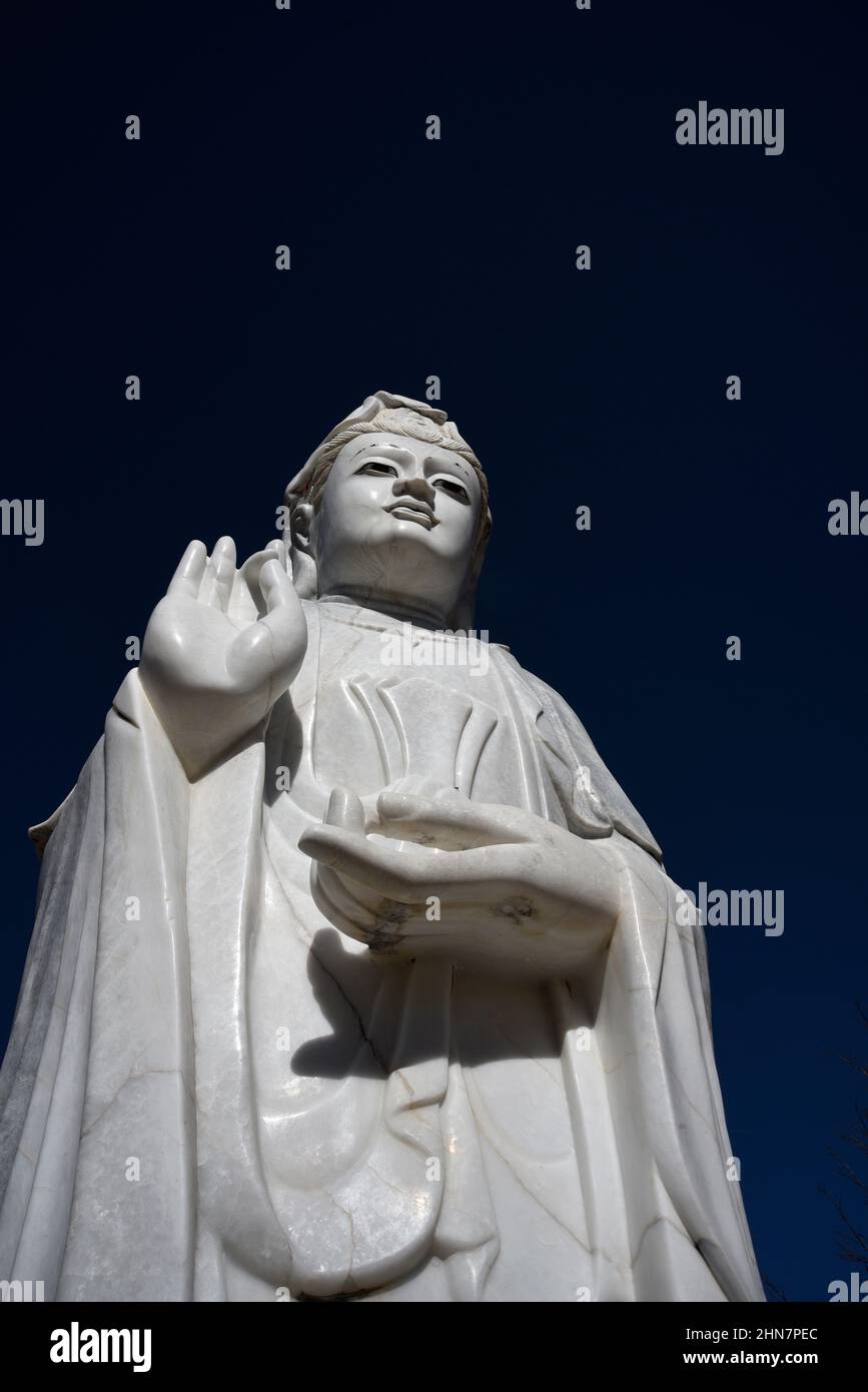 A statue of Quan Am, the bodhisattva of compassion, in front of a ...