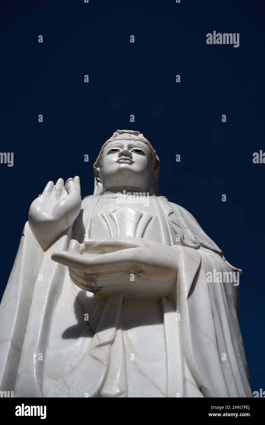 A statue of Quan Am, the bodhisattva of compassion, in front of a ...