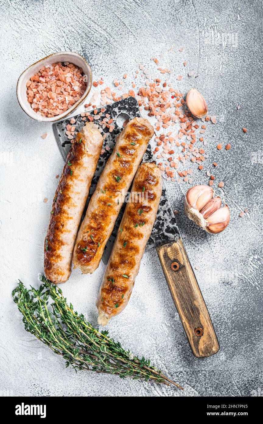 Grilled Bockwurst and Bratwurst meat sausages on a cleaver. White ...