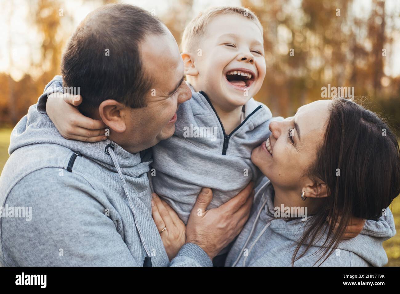 Close-up ortrait of happy family with one kid posing outdoors in public ...