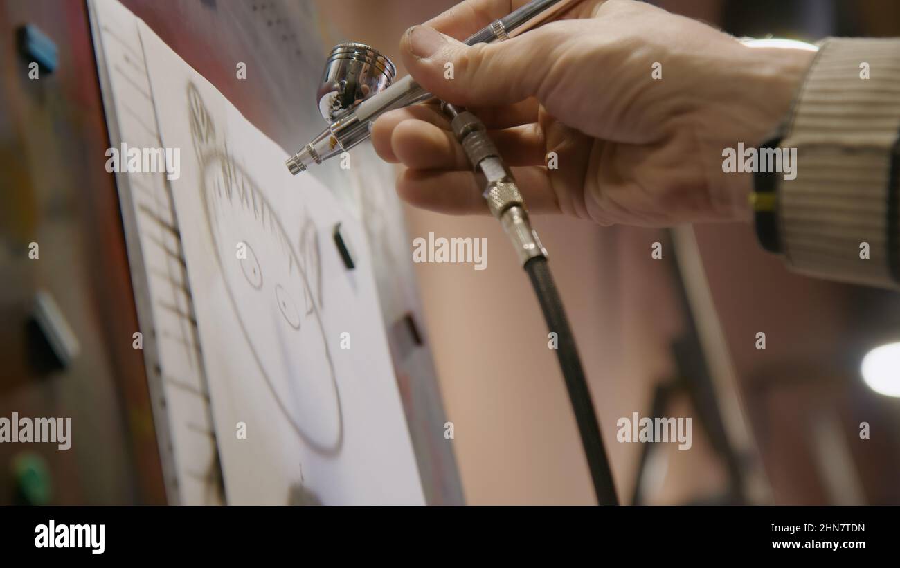 Woman artist learns to paint with airbrush with acrylic dye, paper and ...