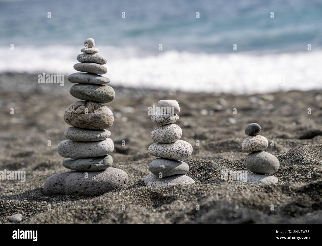 Stones stacked on the seashore under a blue sky Stock Photo - Alamy
