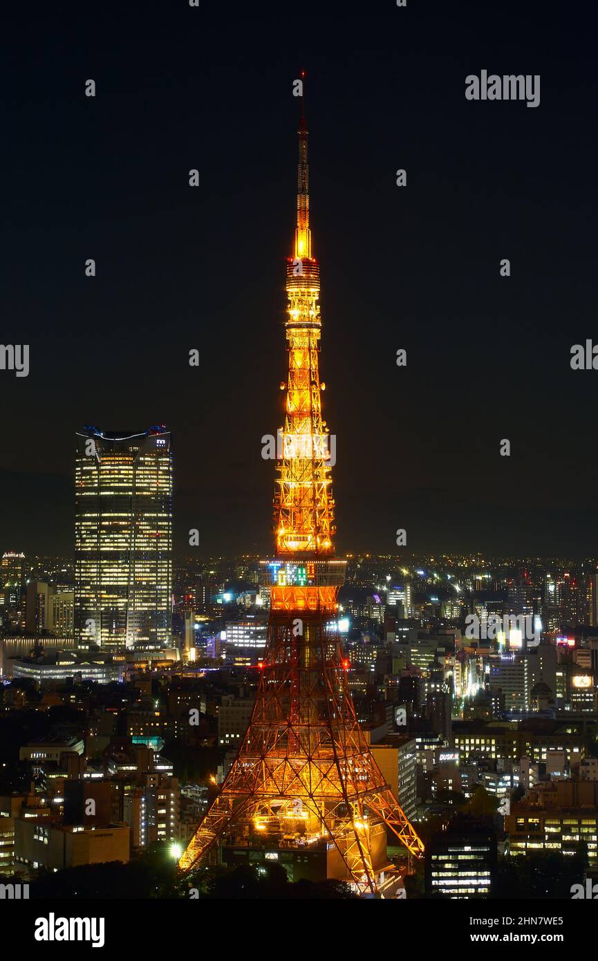 The night view of brightly illuminated red Tokyo tower surrounded by the skyscrapers of Shiba ...