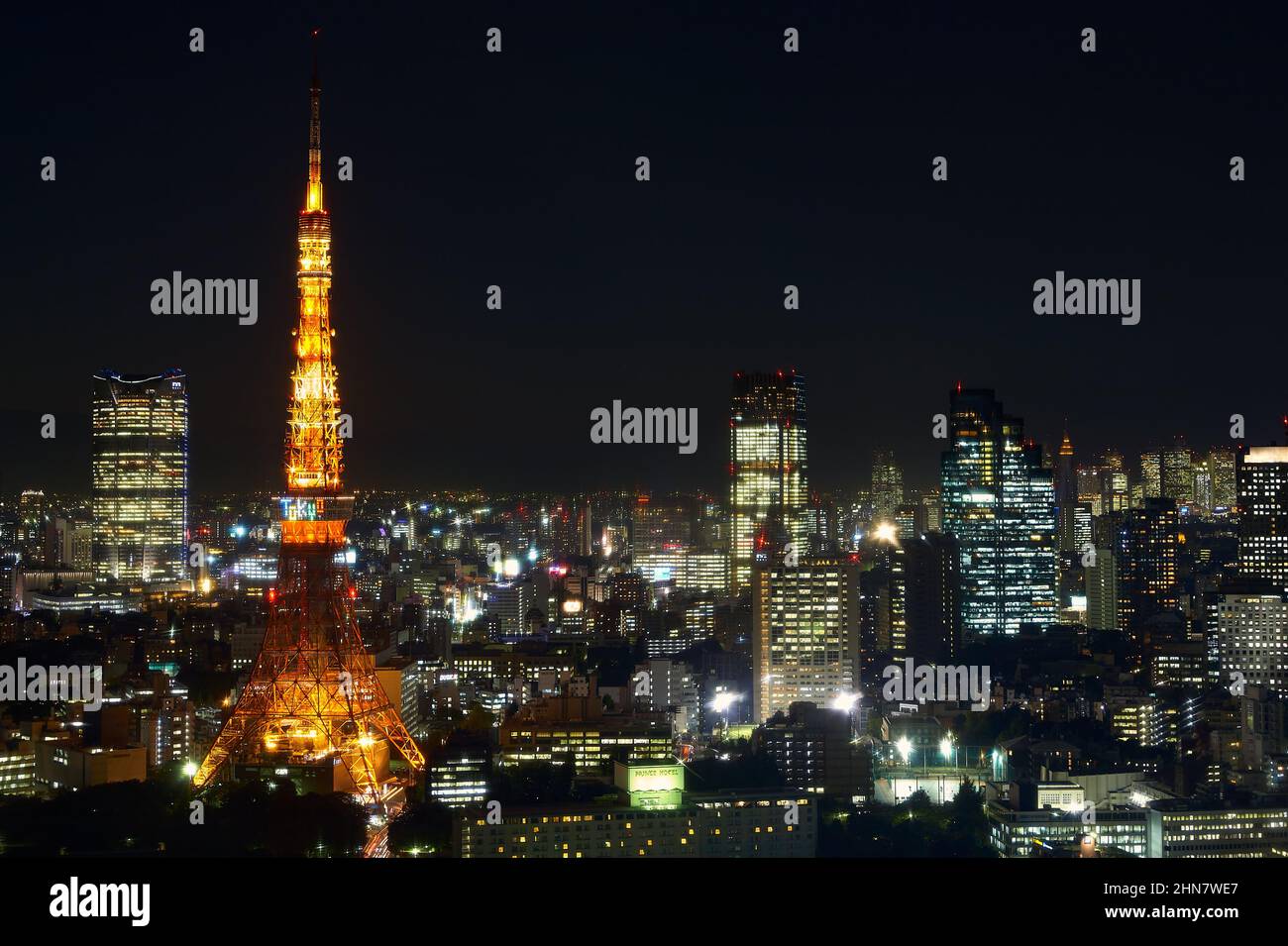 The night view of brightly illuminated red Tokyo tower surrounded by the skyscrapers of Shiba ...