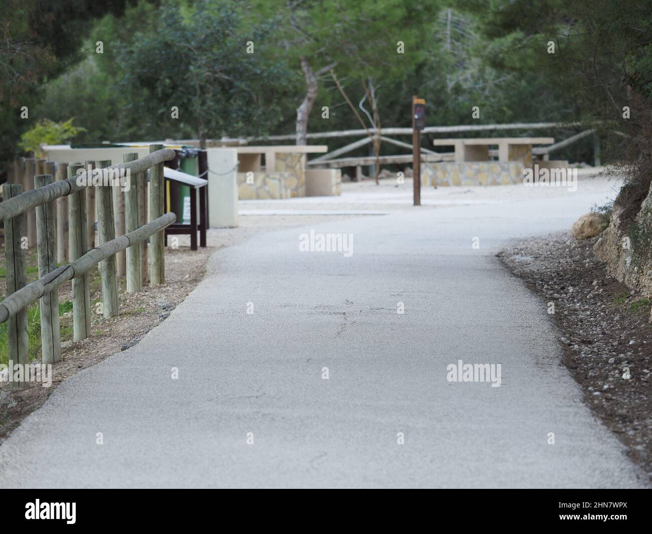 Asphalt road surrounded by a wooden fence in a rural area Stock Photo ...