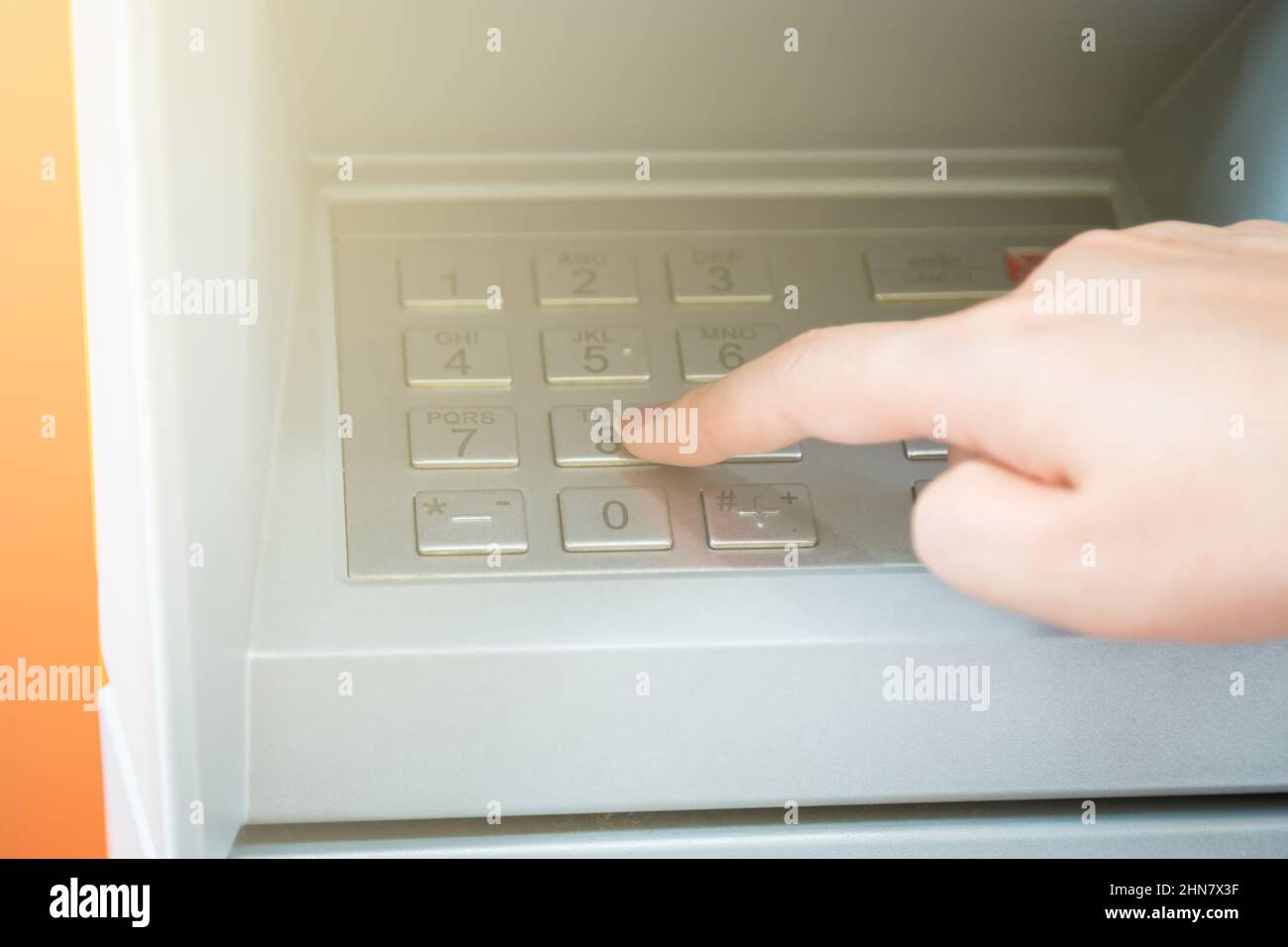 Close up of hand entering pin code at ATM machine to withdraw her money ...