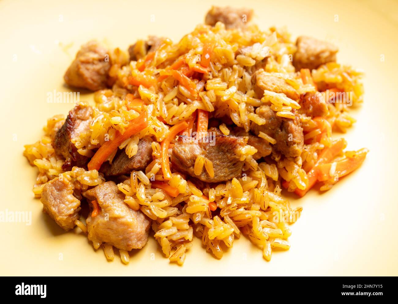 Traditional Uzbekistan pilaf on the rustic background. Selective focus ...