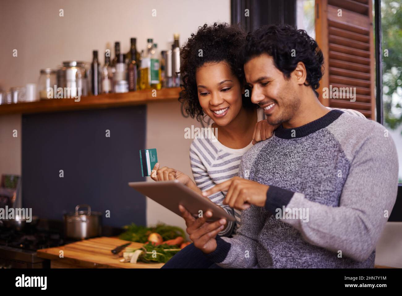 Lets download this recipe. Shot of a young couple using their tablet ...