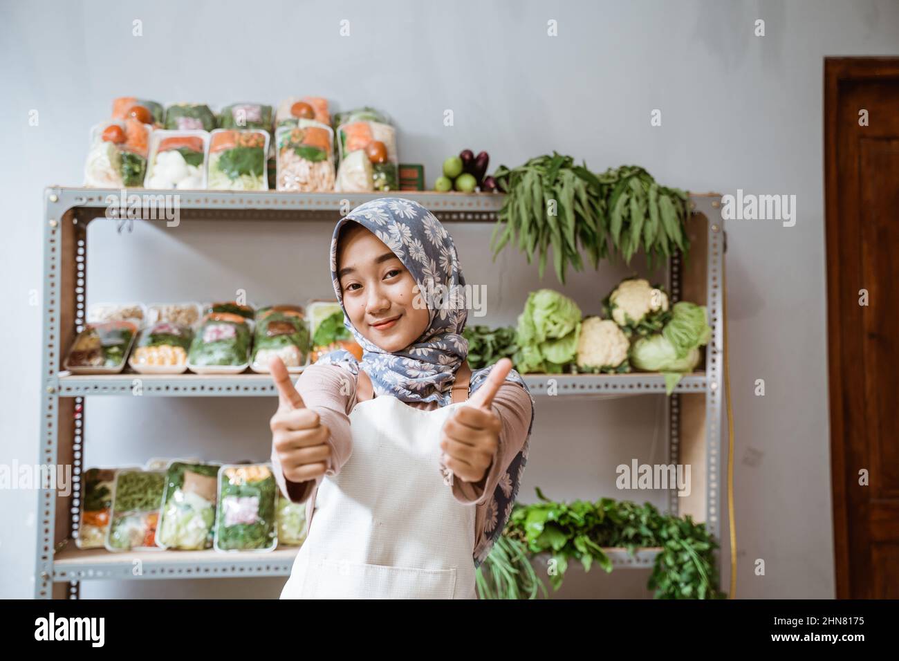 Woman in hijab selling vegetables showing two thumbs up Stock Photo - Alamy