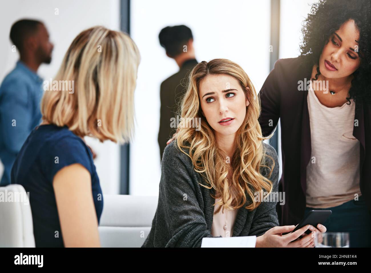 Its my last day here. Shot of a sad young woman being comforted by her ...
