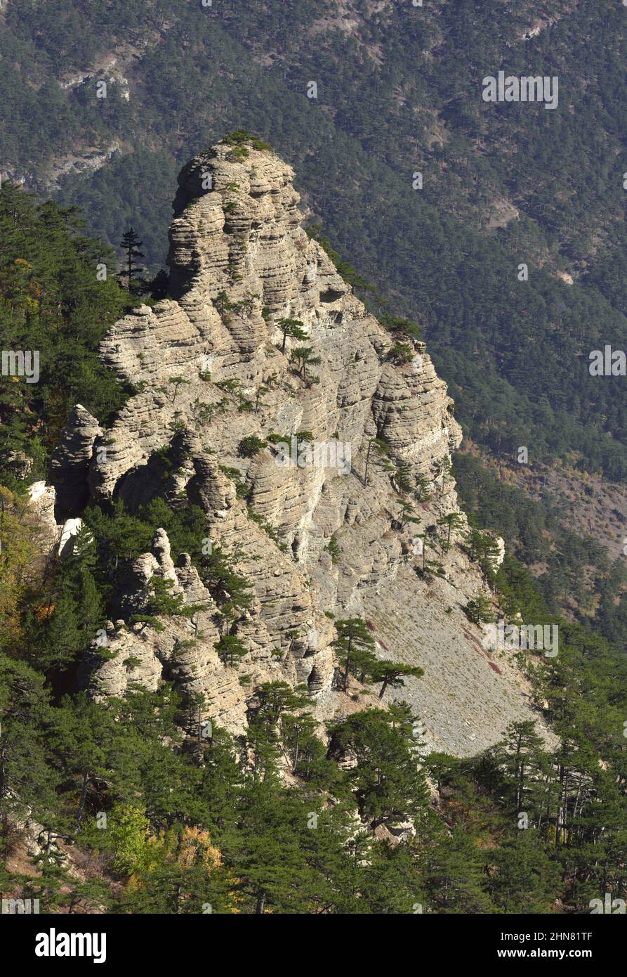 High rock-remnant with geological sedimentary layers in the mountains ...