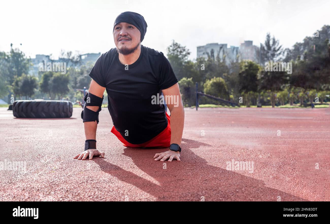 Latin man doing cobra stretch and exercising in a park. Concept of ...