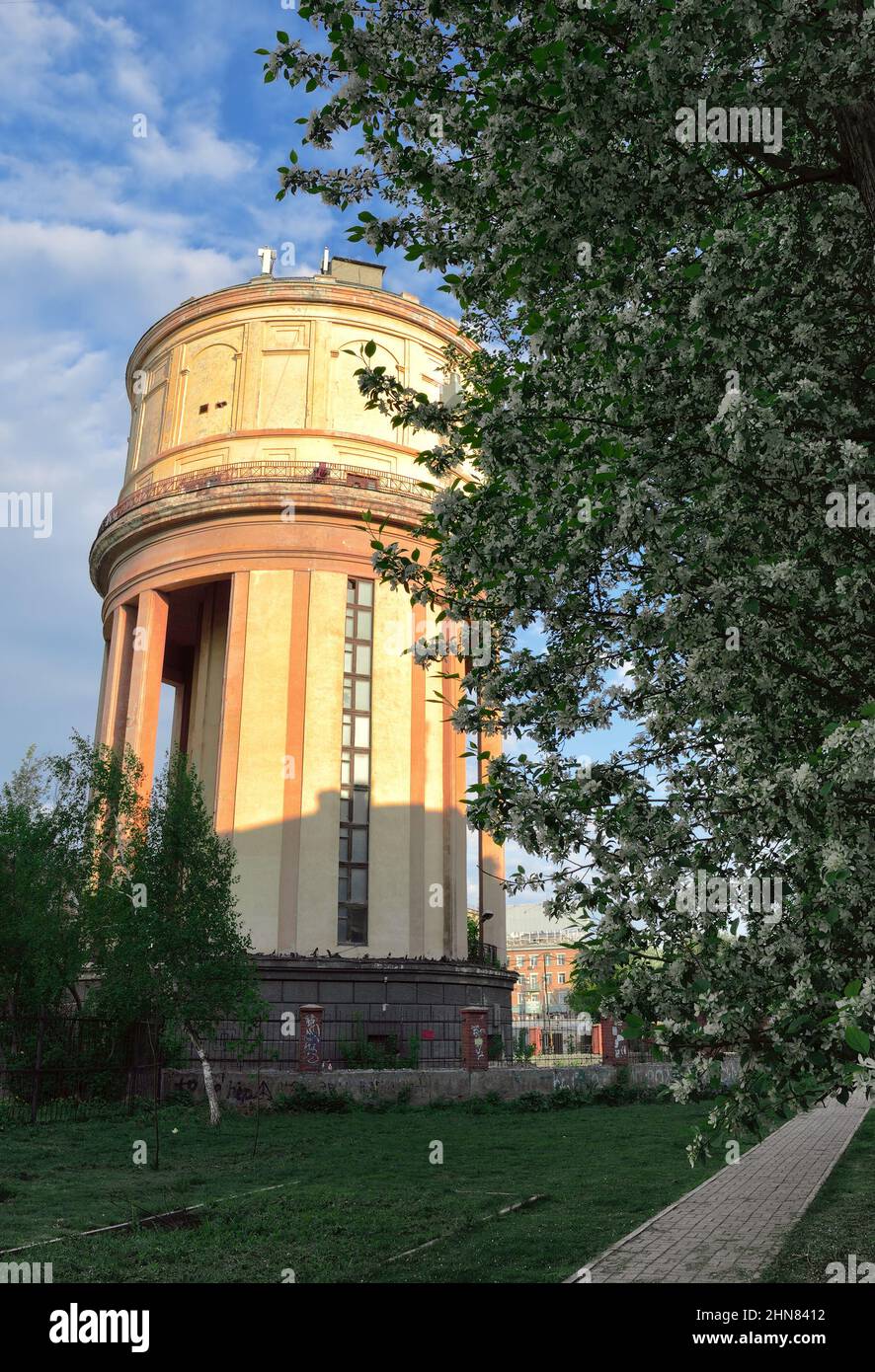 A tall classical-style tower on Karl Marx street, a blooming tree in ...