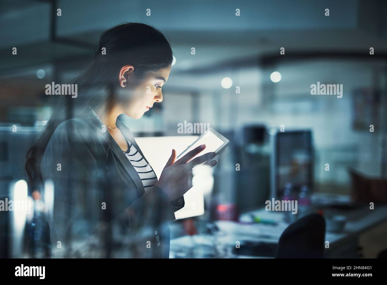 Alone in the office getting work done. Shot of a young businesswoman ...