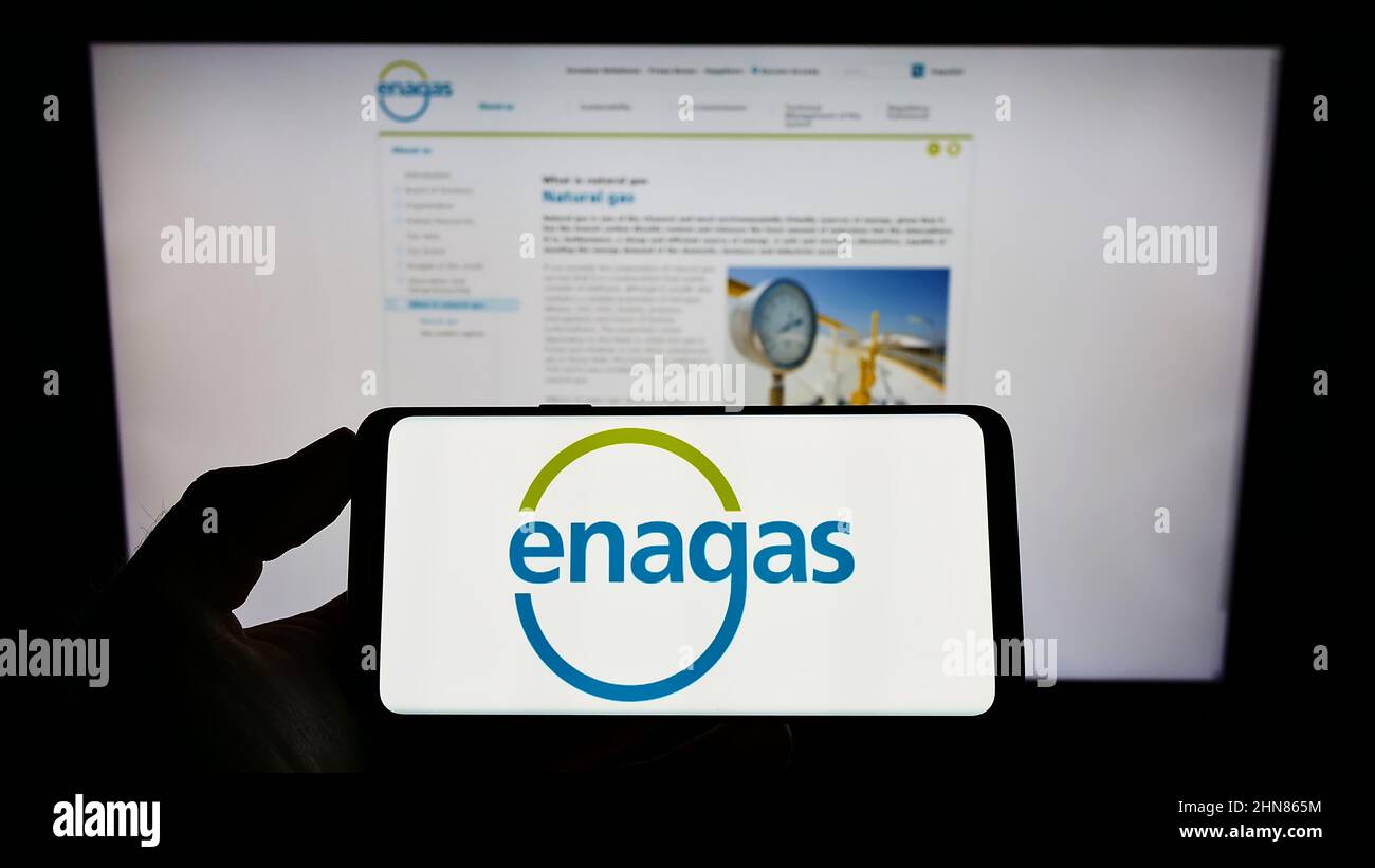 Person holding cellphone with logo of Spanish gas distribution company ...