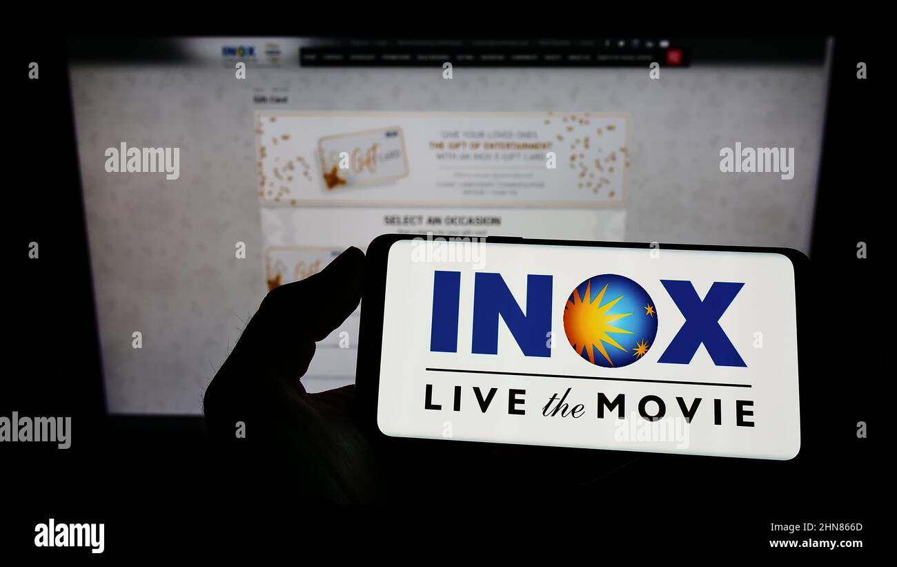 Person holding cellphone with logo of Indian cinema company INOX ...