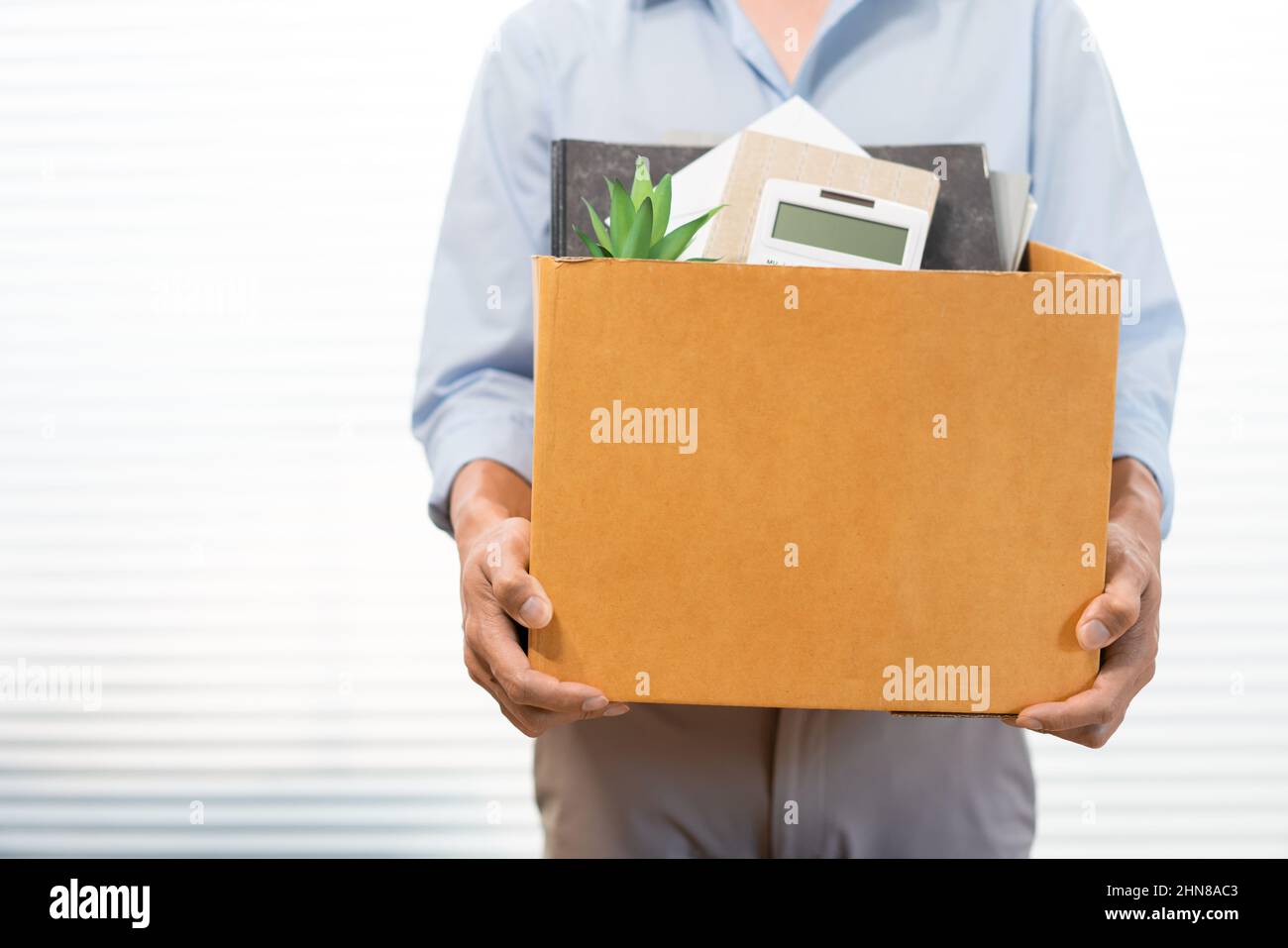 Resignation Concept The male standing and using his hands lifting a box ...