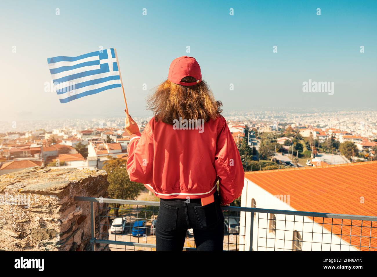Happy student girl with a Greek flag at city viewpoint. The concept of ...