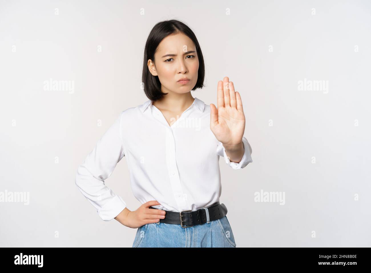 Portrait of young woman extending one hand, stop taboo sign, rejecting ...